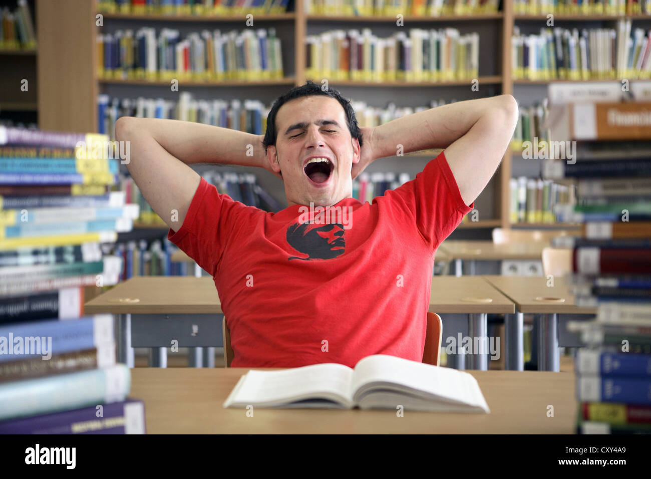Student yawning and being lazy in a university library Stock Photo - Alamy