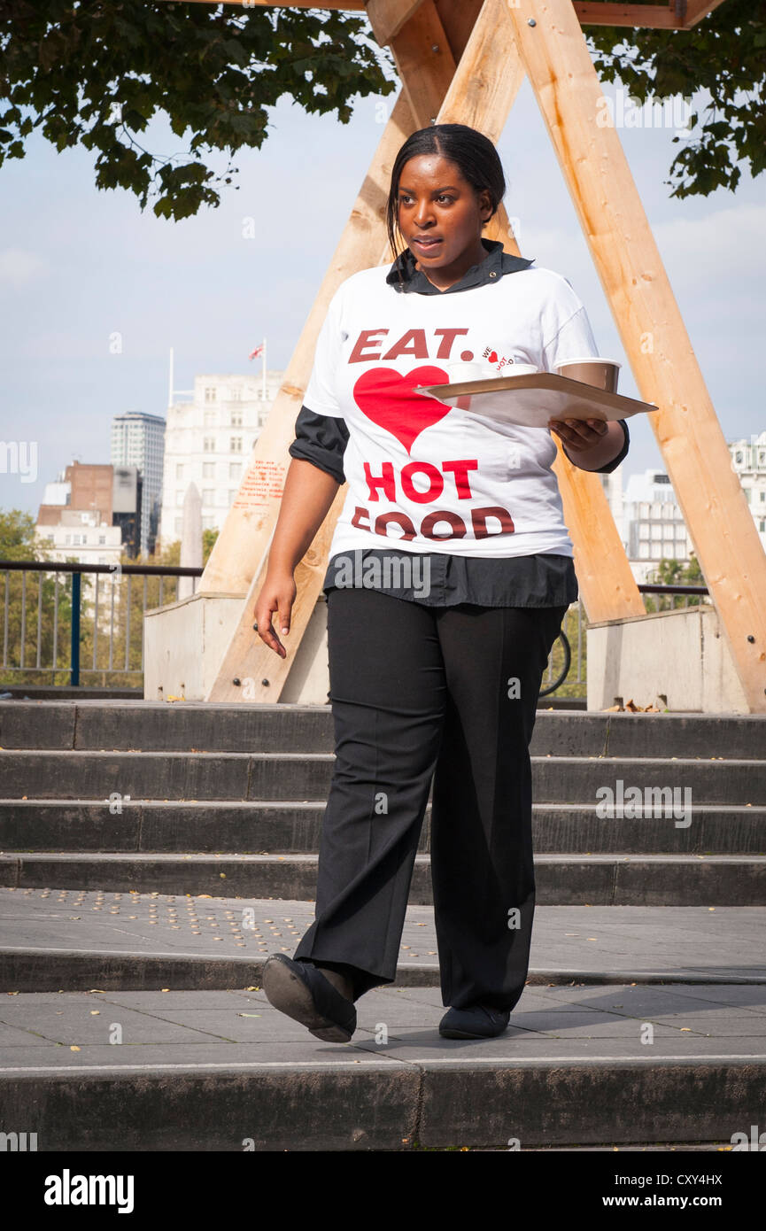 London Southbank Eat pretty young female black waitress ponytail hands ...