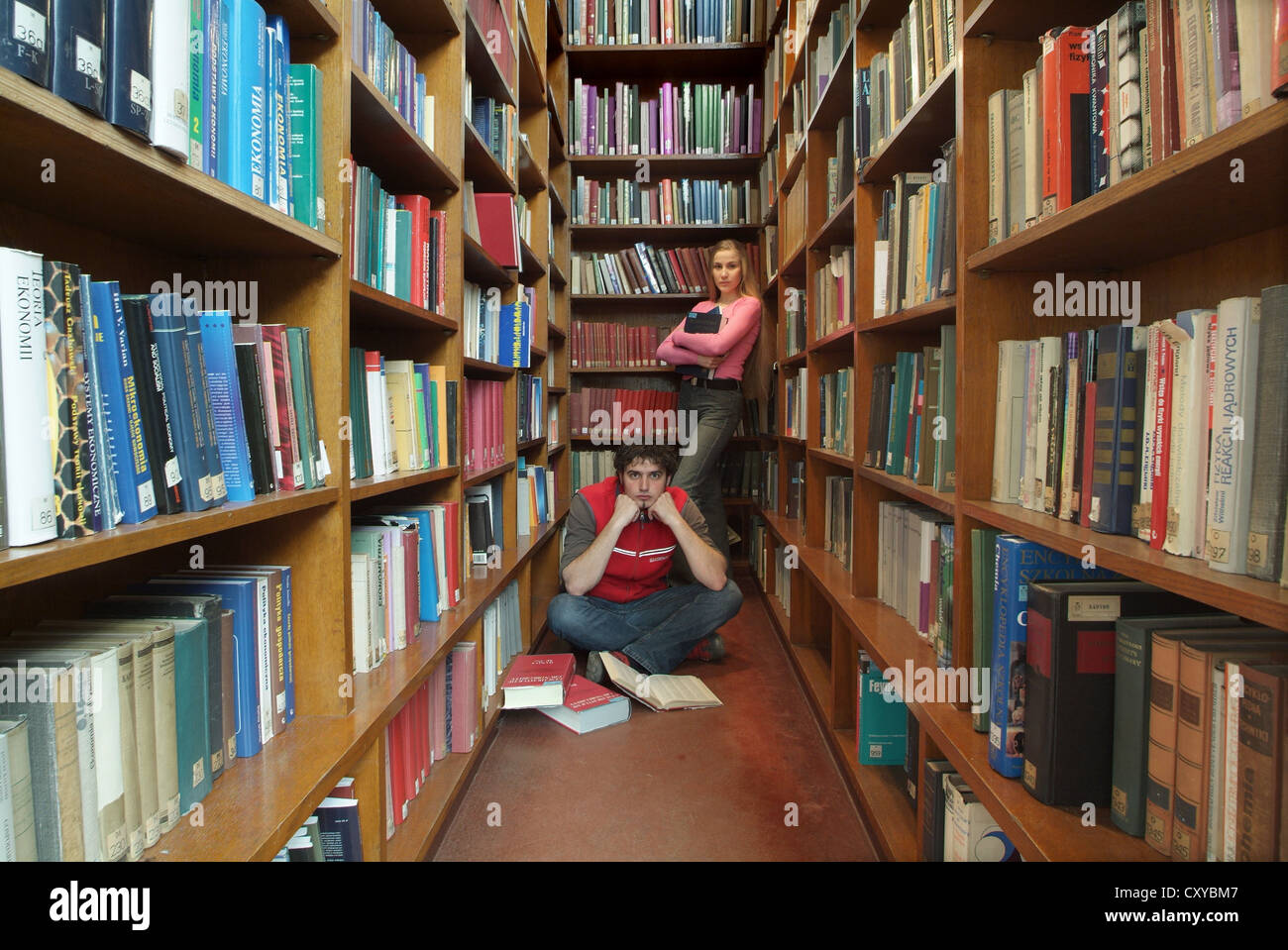 Students between bookshelves in a university library Stock Photo - Alamy