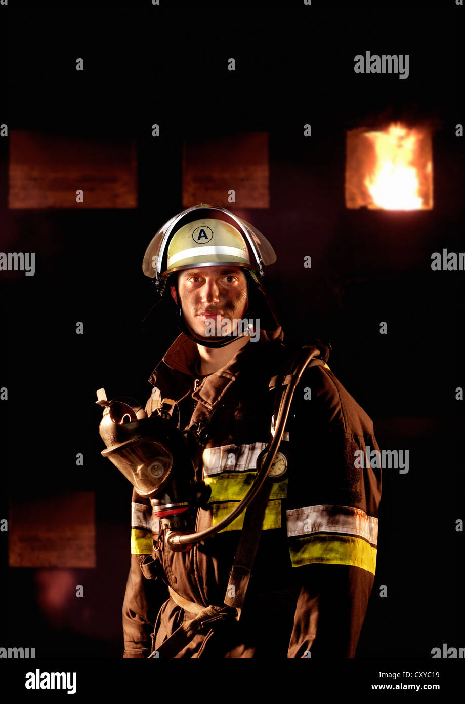 Firefighter in front of a burning building Stock Photo - Alamy