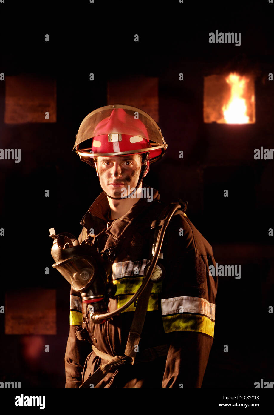 Firefighter in front of a burning building Stock Photo - Alamy