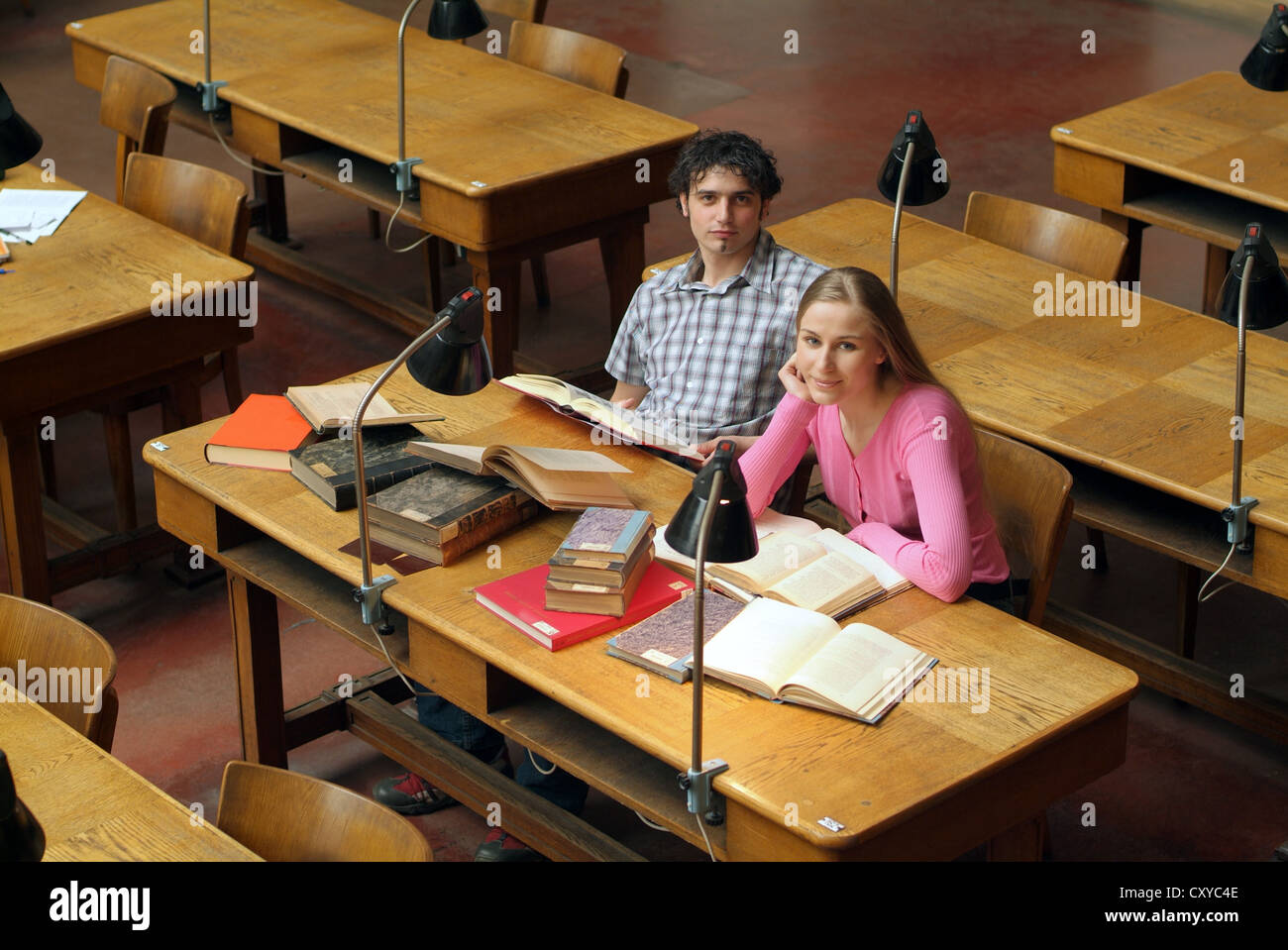 Students studying at a desk in a university library Stock Photo - Alamy