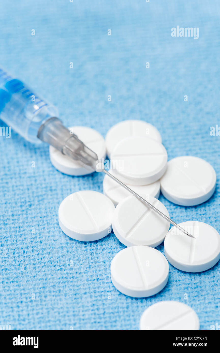 Injection needle with prescription pills blue background Stock Photo ...