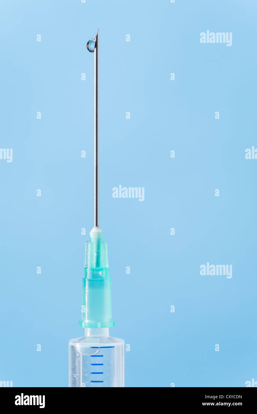 Medical syringe drop falling from needle on blue background Stock Photo ...
