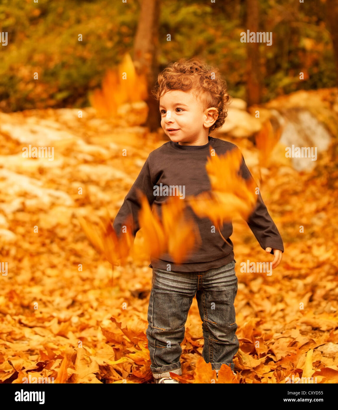 Photo of cheerful small kid having fun outdoors, adorable toddler play ...