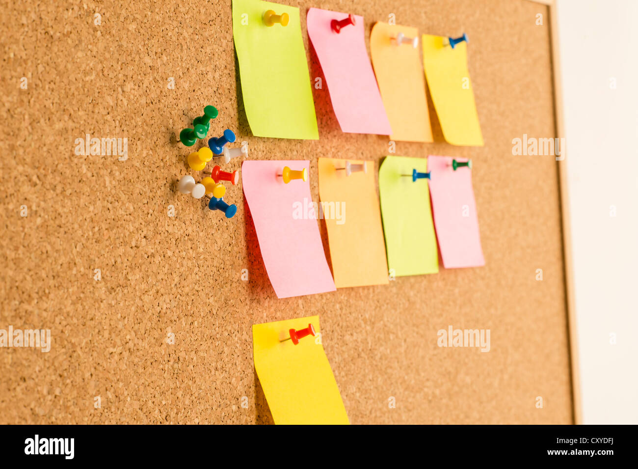 Post-it reminder sticker note with pins on board Stock Photo - Alamy