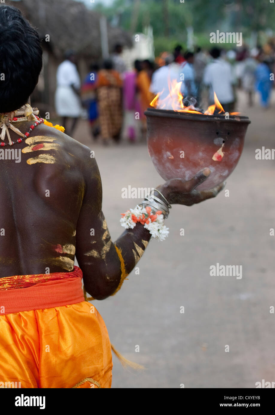 Rear View Of A Man With Painting On His Body Holding A Jar On Fire In ...