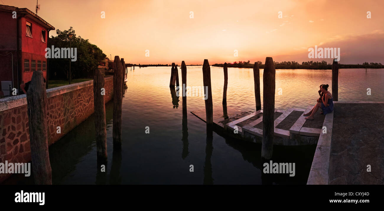 Mother and daughter watching the sunset at Cavallino, Venice, Veneto ...