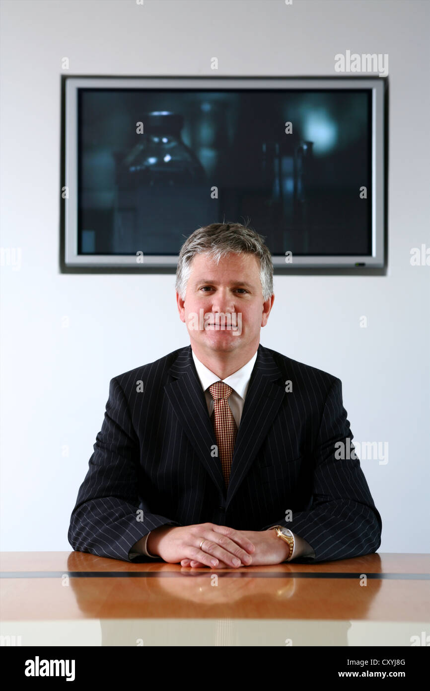 Gary Savage sat behind desk Stock Photo - Alamy