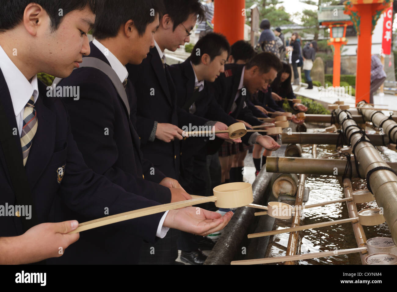 Young Japanese people drinking fresh spring water at Fushiminari temple ...