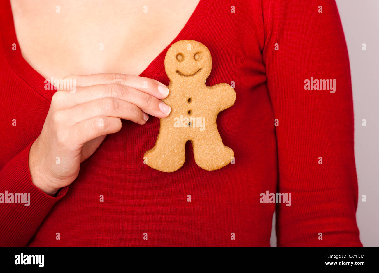 Female hand holding a gingerbread cookie close to her heart Stock Photo ...