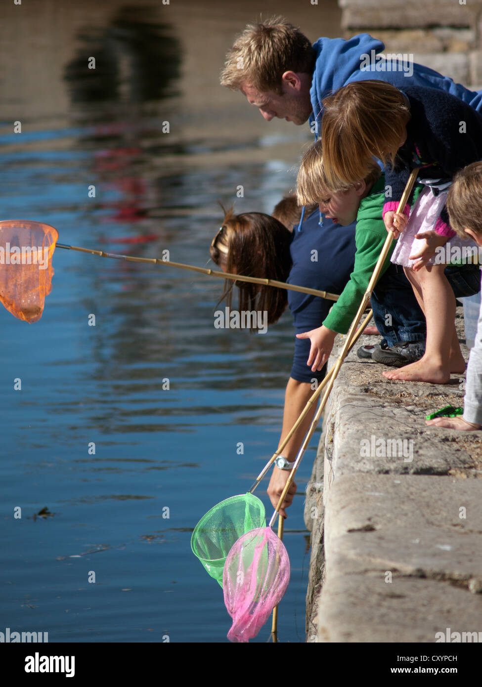 A family with nets try to catch crabs in the harbour at Poole, England ...
