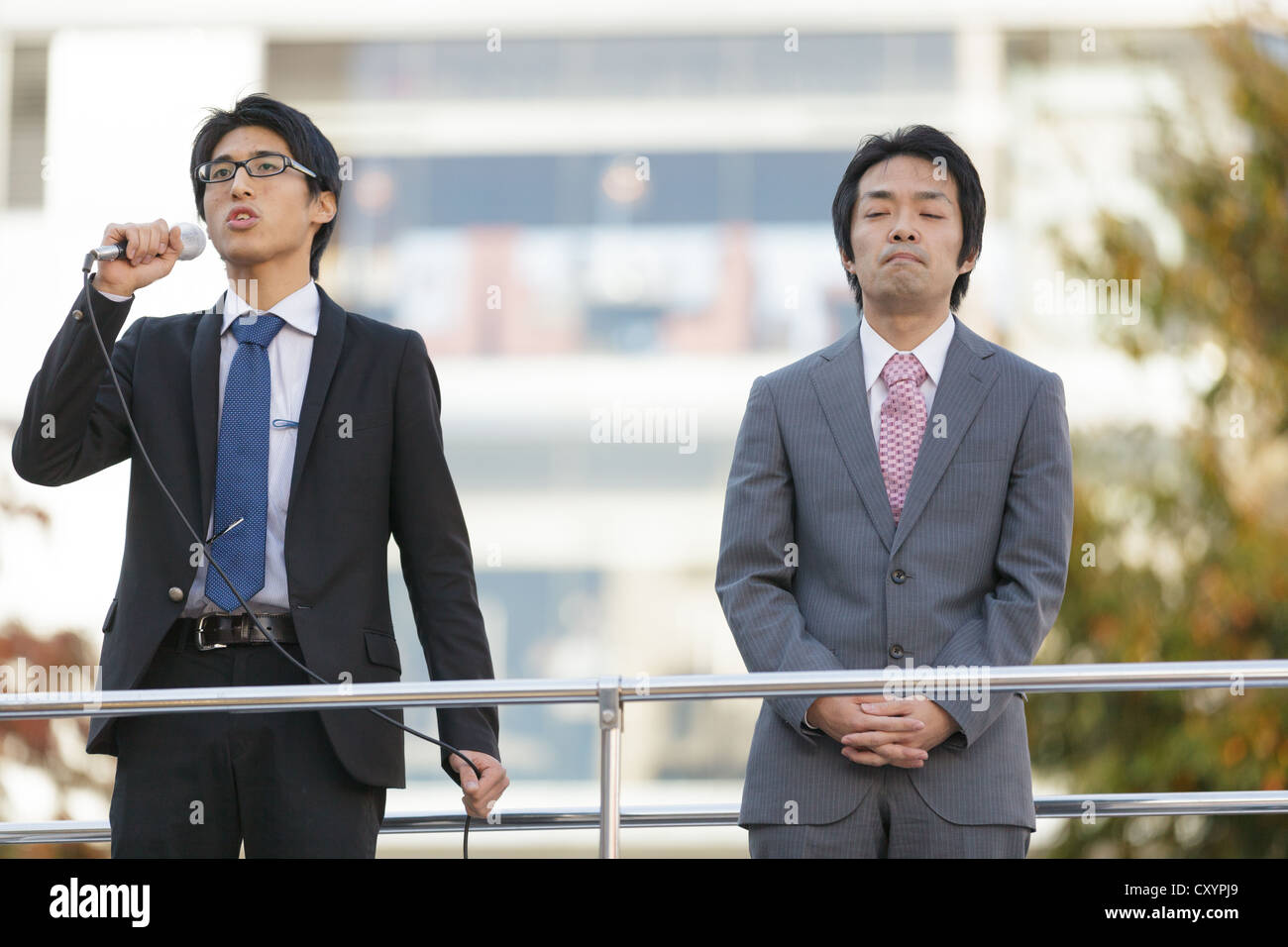Two Japanese men speaking outdoors in Shibuya district, Tokyo, Japan ...