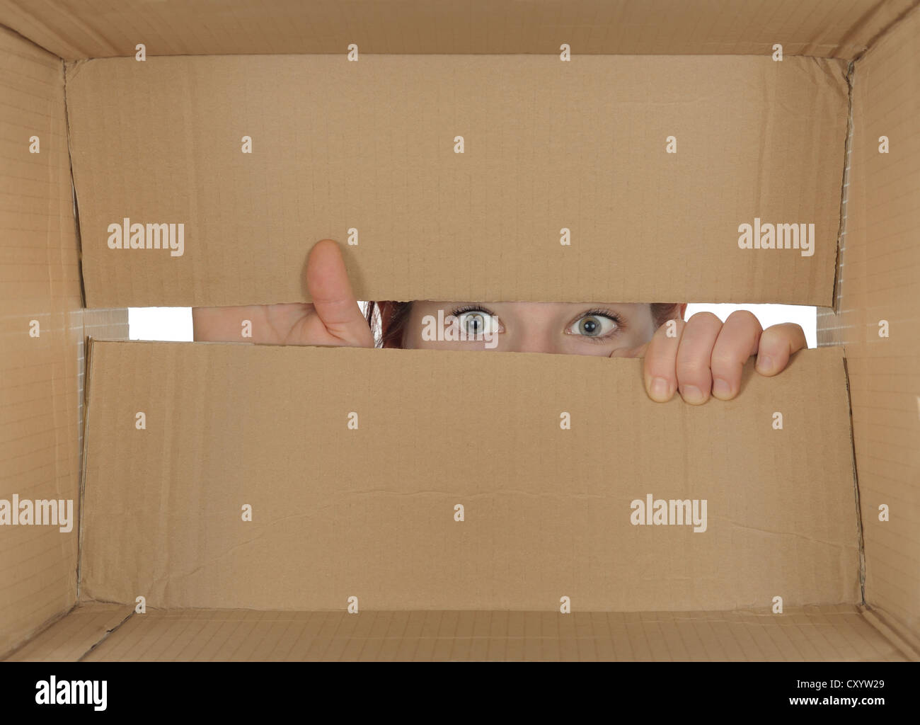 Curious woman looking through a cardboard Stock Photo - Alamy