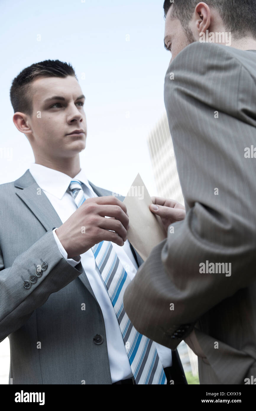 Businessman handing over an envelope Stock Photo - Alamy