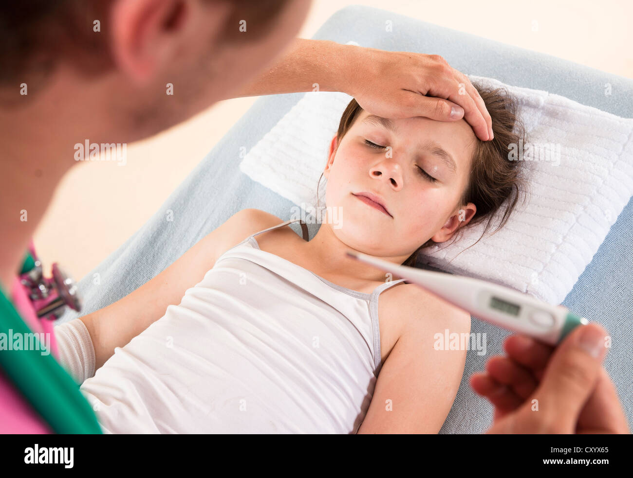 Pediatrician reading a digital fever thermometer showing the high ...