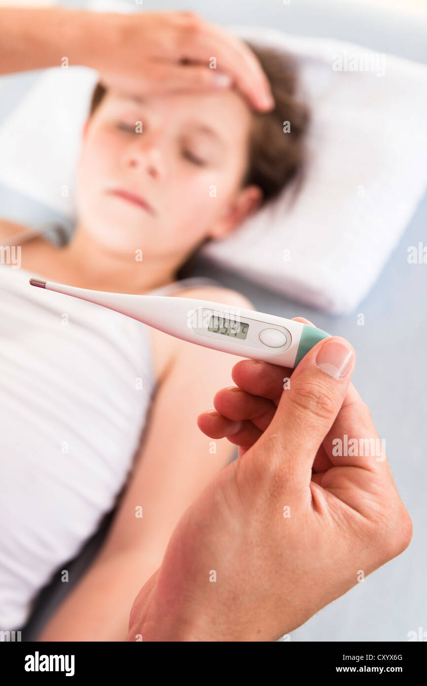 Digital fever thermometer showing the high temperature of a young girl ...
