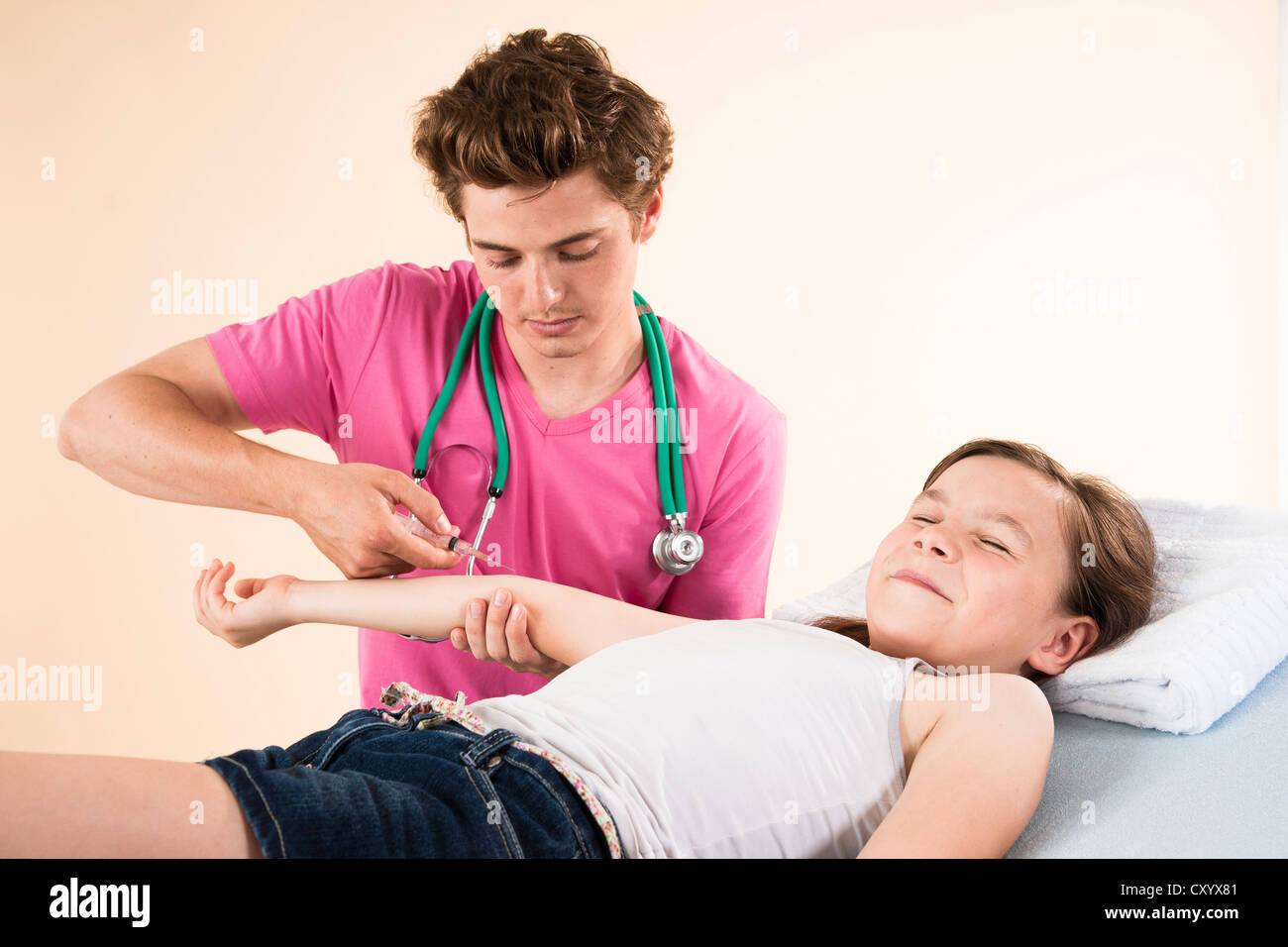Girl looking afraid while getting a needle from her pediatrician Stock ...