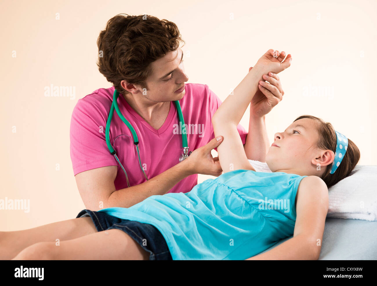 Girl having her arm examined by her pediatrician Stock Photo - Alamy