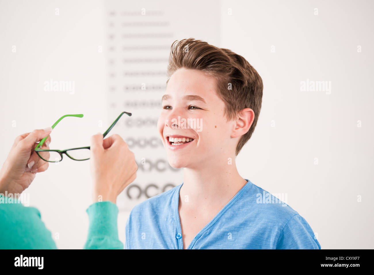 Teenage boy getting new glasses at the optician Stock Photo - Alamy