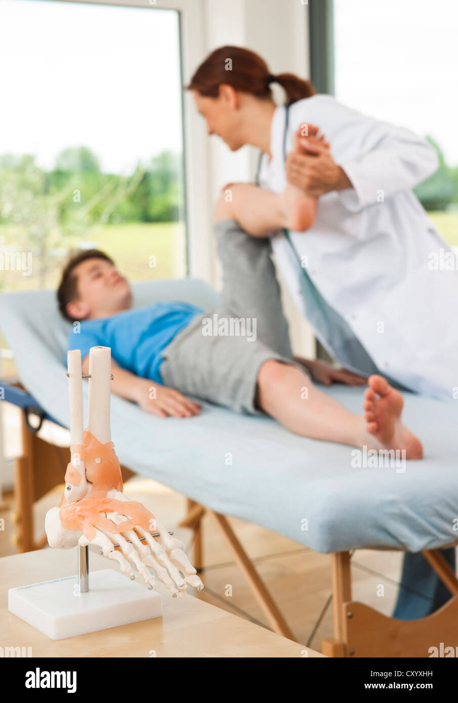 Orthopedic surgeon examining a teenage boy's injured leg Stock Photo ...