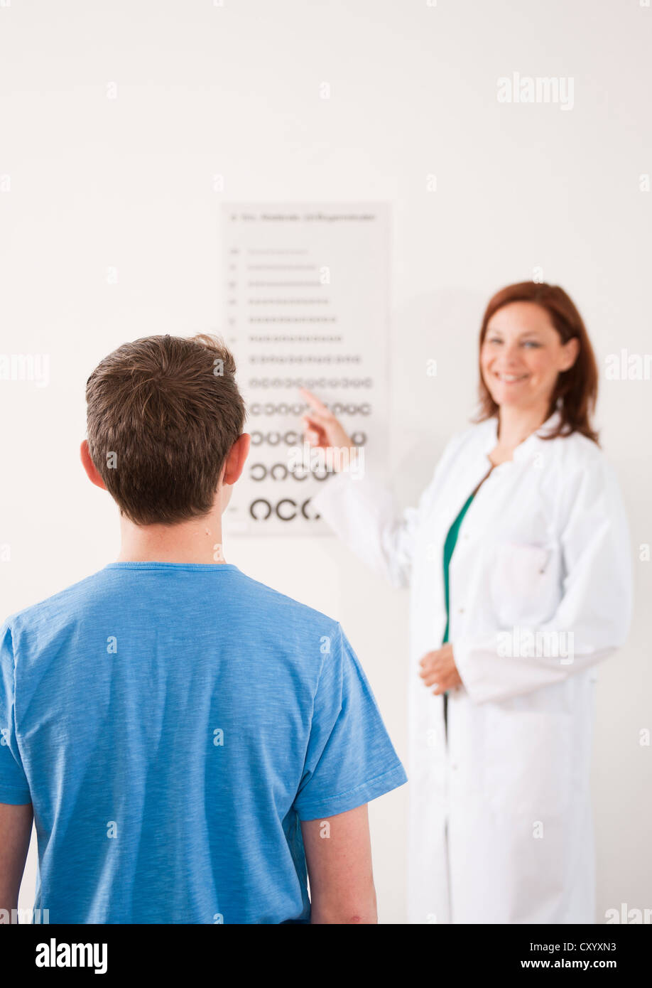 Teenage boy completing an eyesight test with an ophthalmologist Stock ...