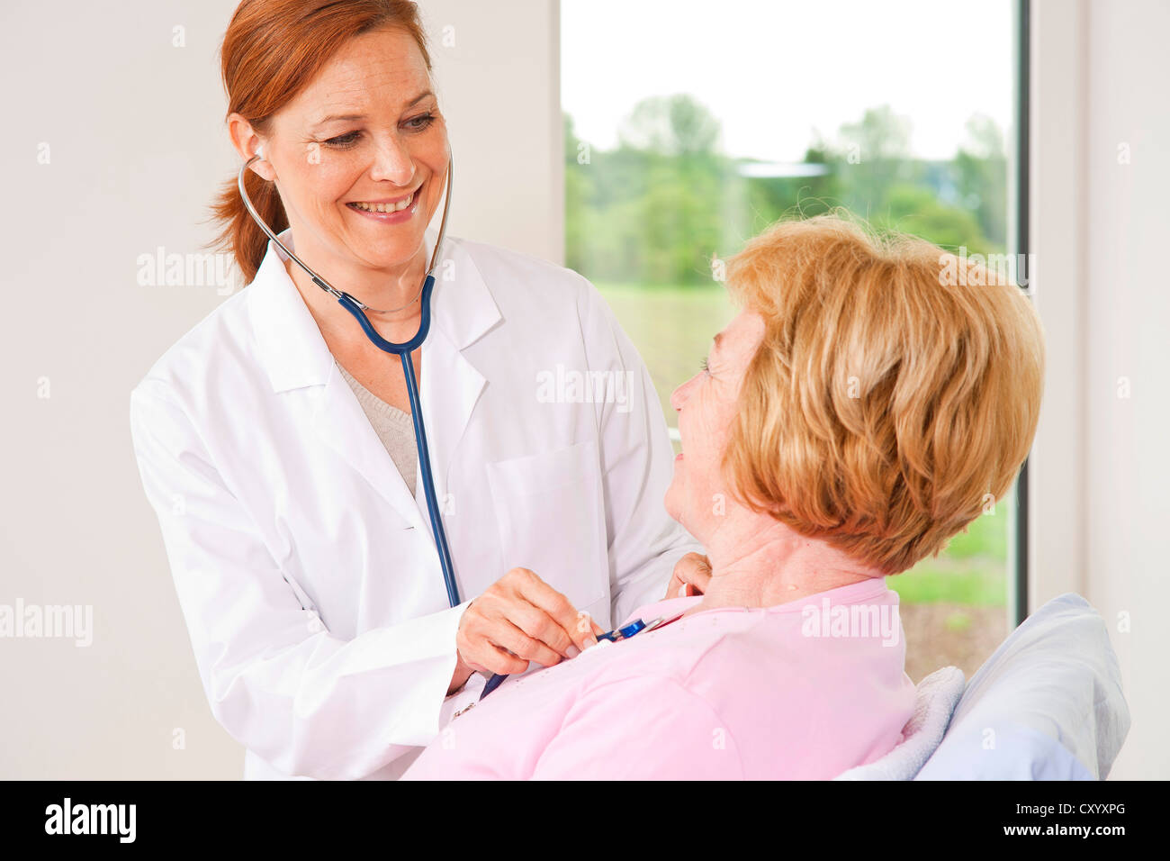 Patient being monitored by her family doctor with a stethoscope Stock ...