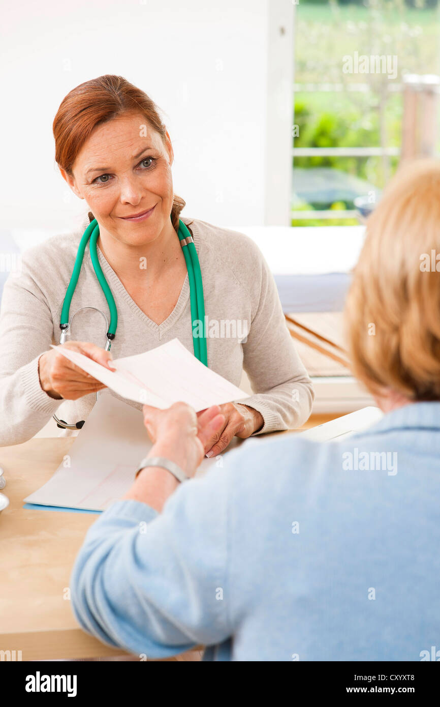 Patient in consultation with her doctor in a practice and getting a ...