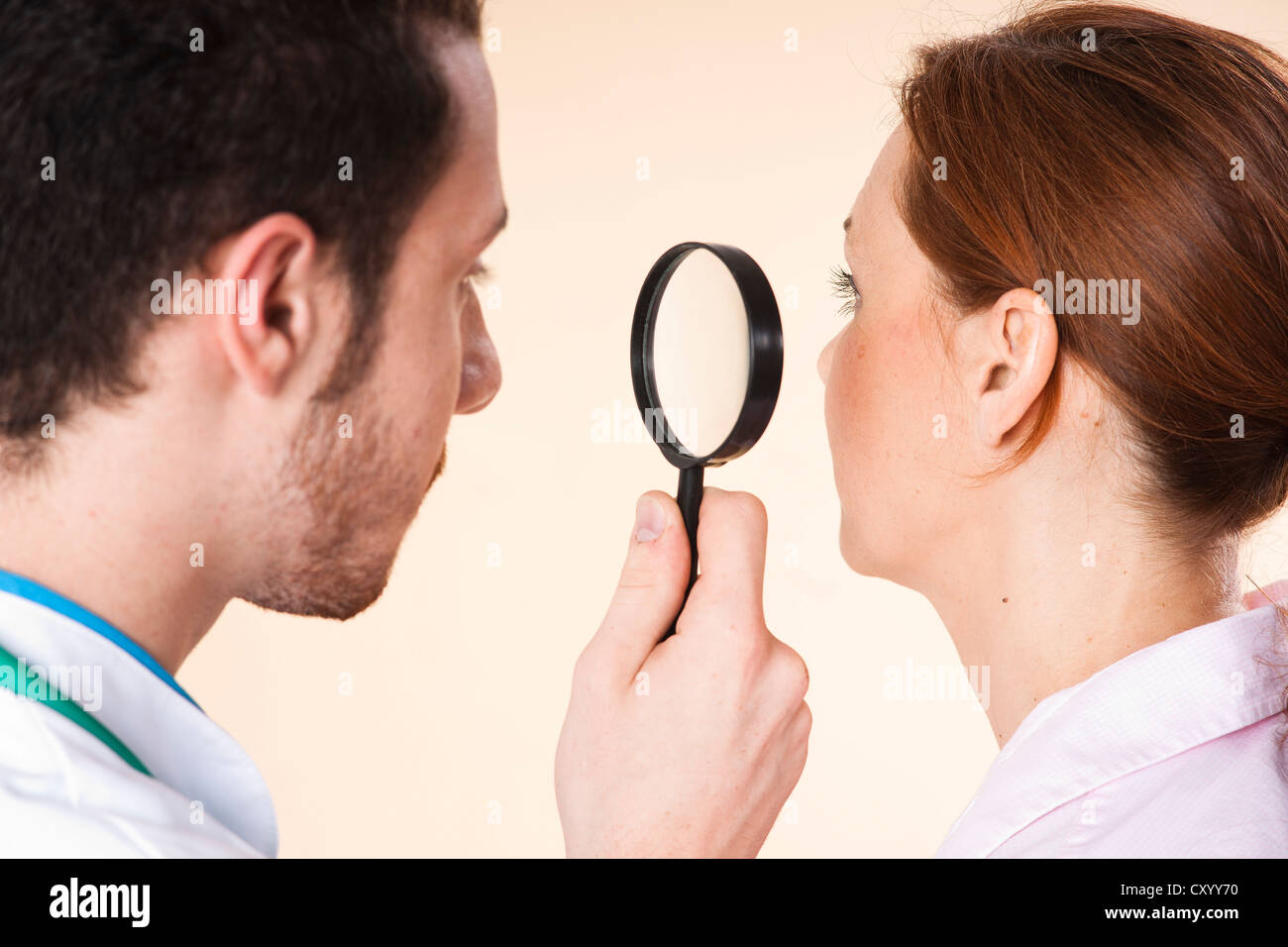 Dermatologist examining a suspicious skin area of a patient with a ...