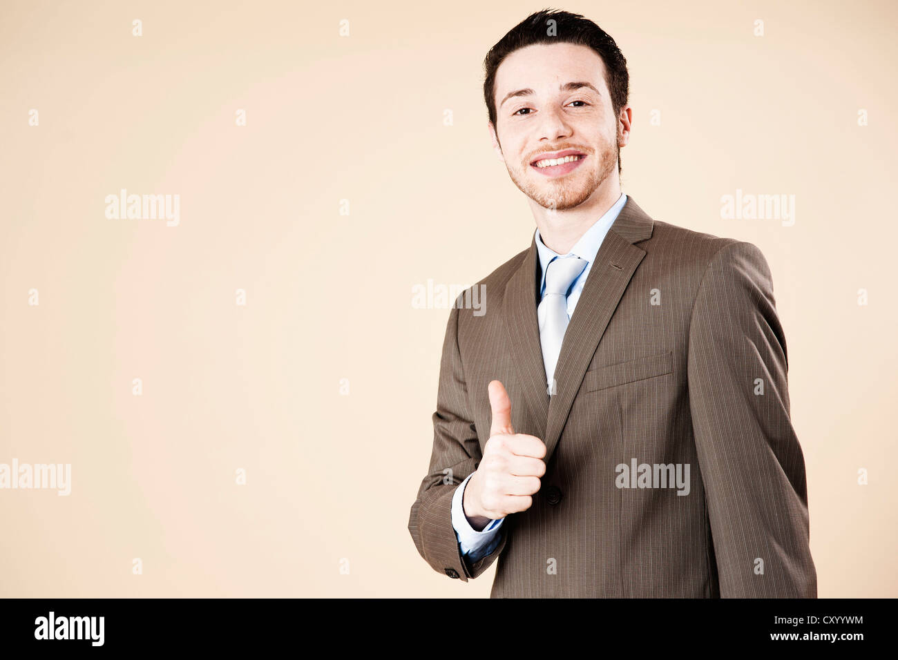 Smiling businessman making a thumbs-up gesture Stock Photo - Alamy