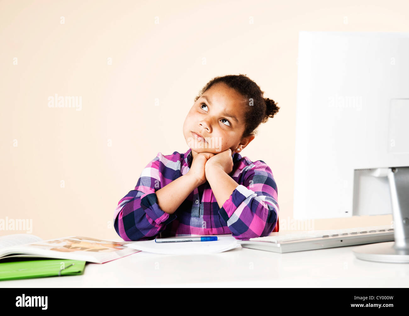 Girl sitting and thinking at her desk Stock Photo - Alamy