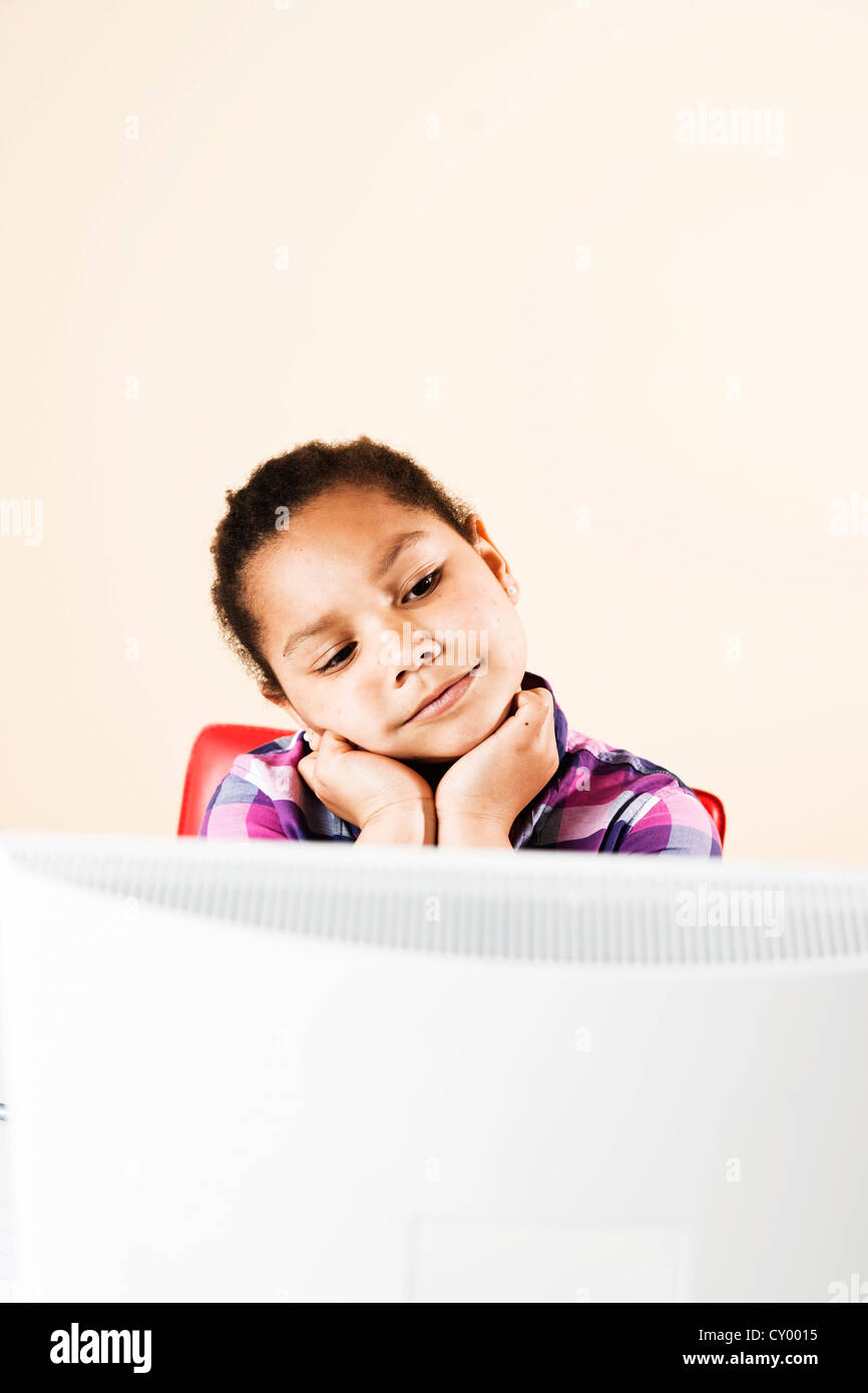 Girl looking pensively at her monitor Stock Photo - Alamy