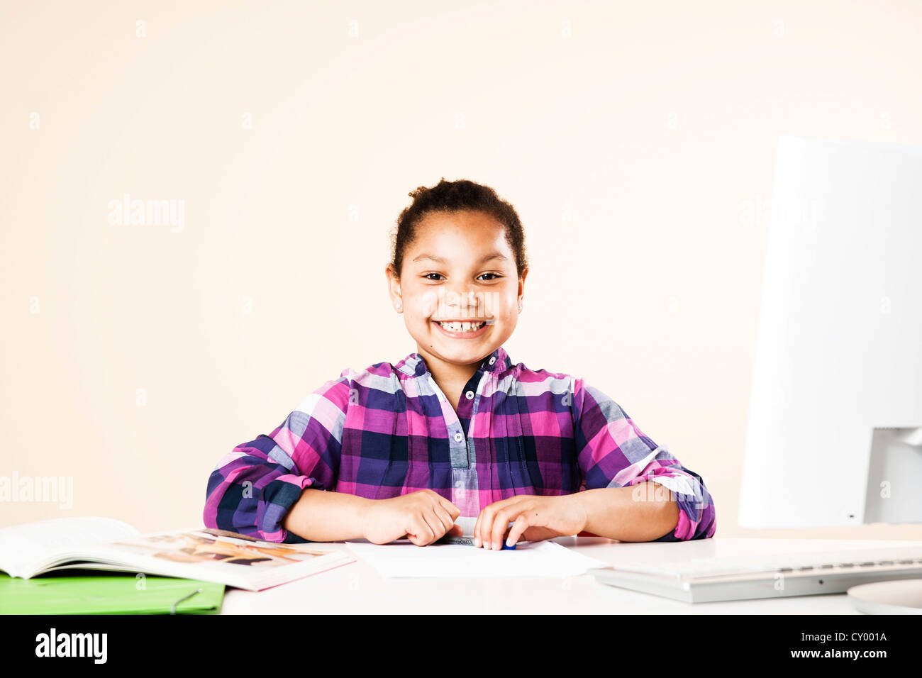 Smiling girl sitting at a desk Stock Photo - Alamy
