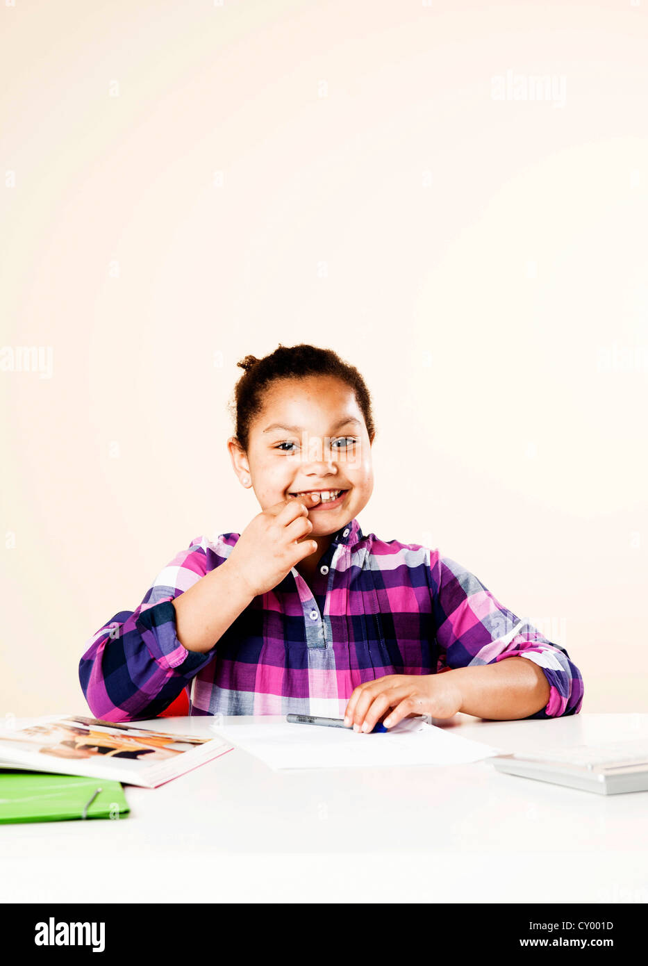 Smiling girl sitting at a desk Stock Photo - Alamy