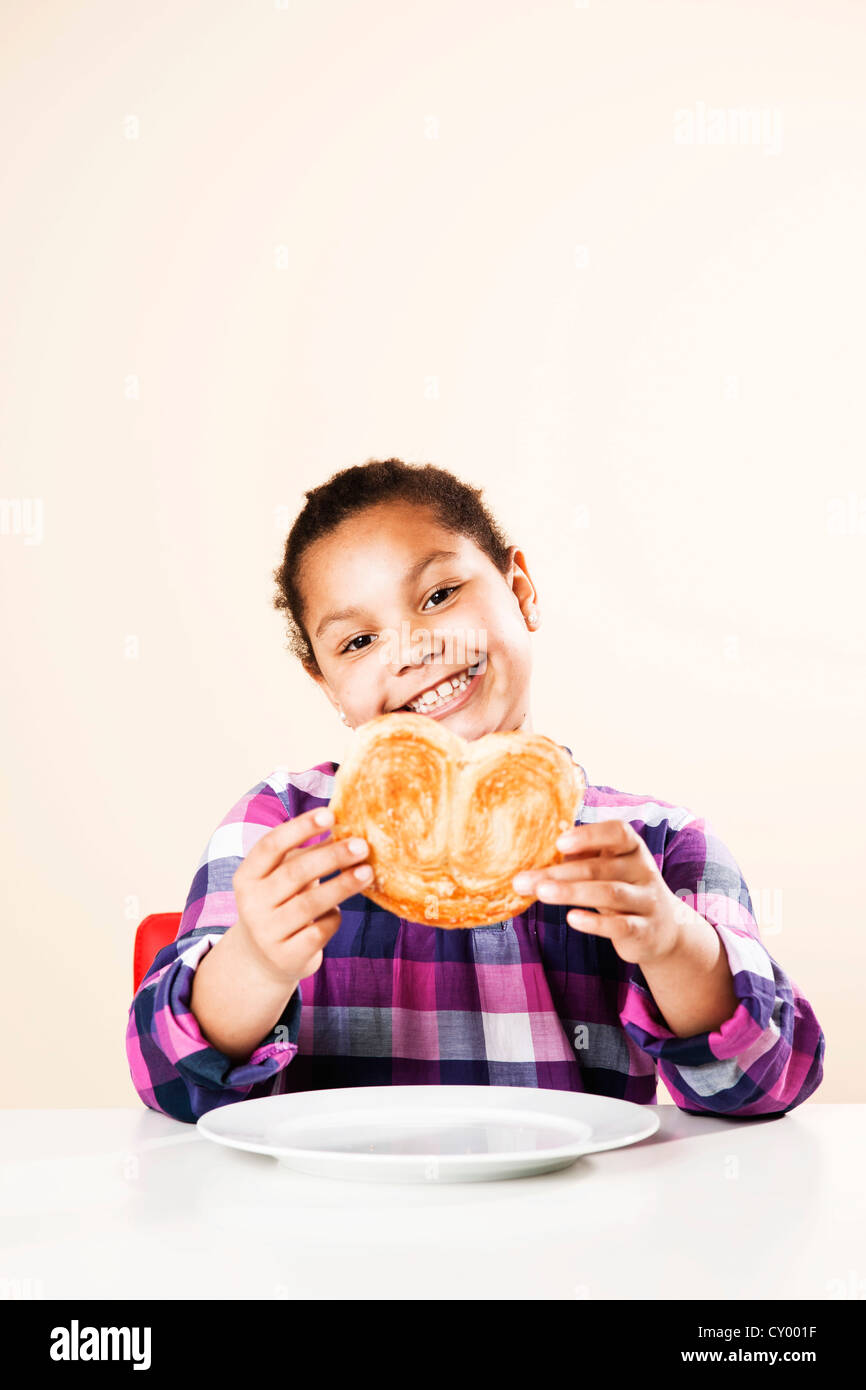 Girl looking hungrily at a piece of sweet pastry Stock Photo - Alamy