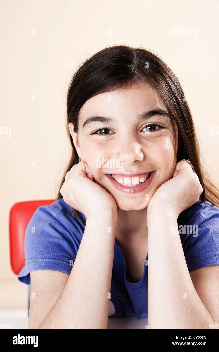 Smiling girl with her hands supporting her head Stock Photo - Alamy