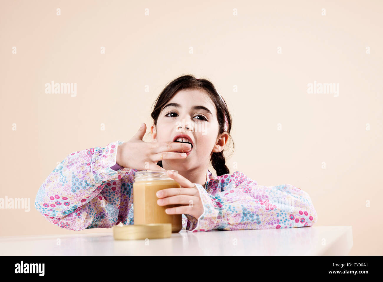 Girls nibbling enjoyably from a jar of honey Stock Photo - Alamy