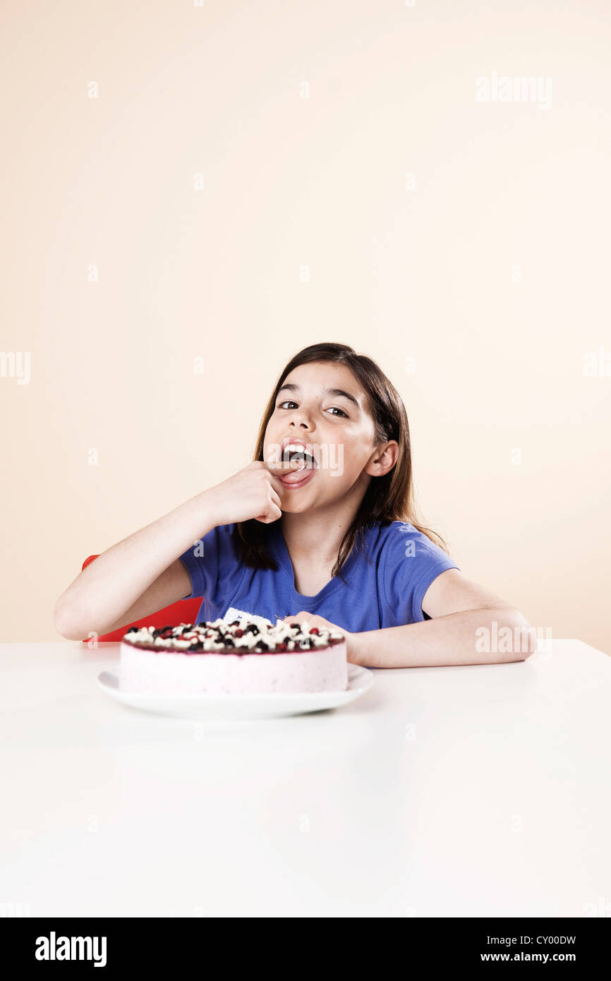 Girl nibbling from a cake Stock Photo - Alamy