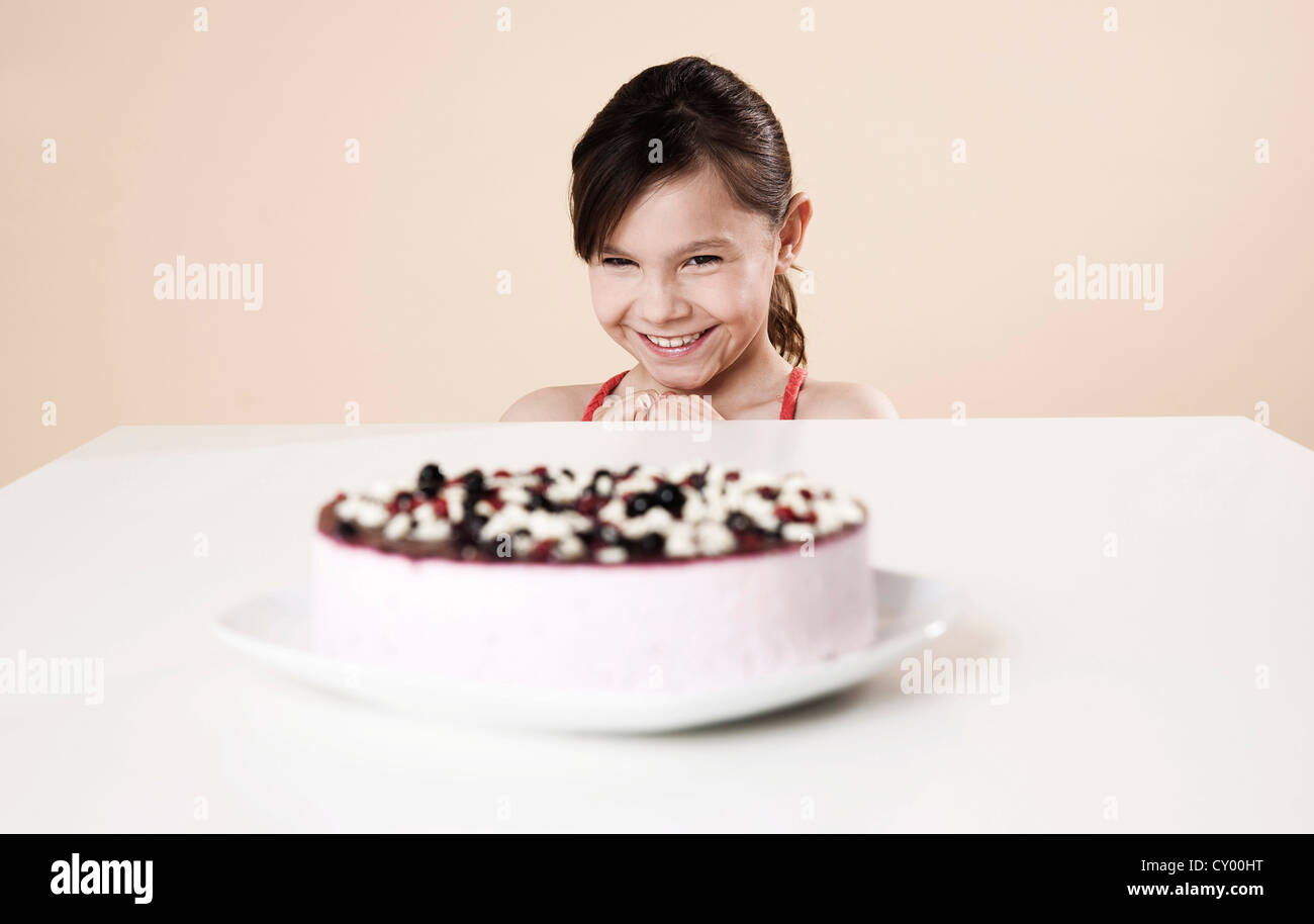 Girl looking hungrily towards a cake Stock Photo - Alamy