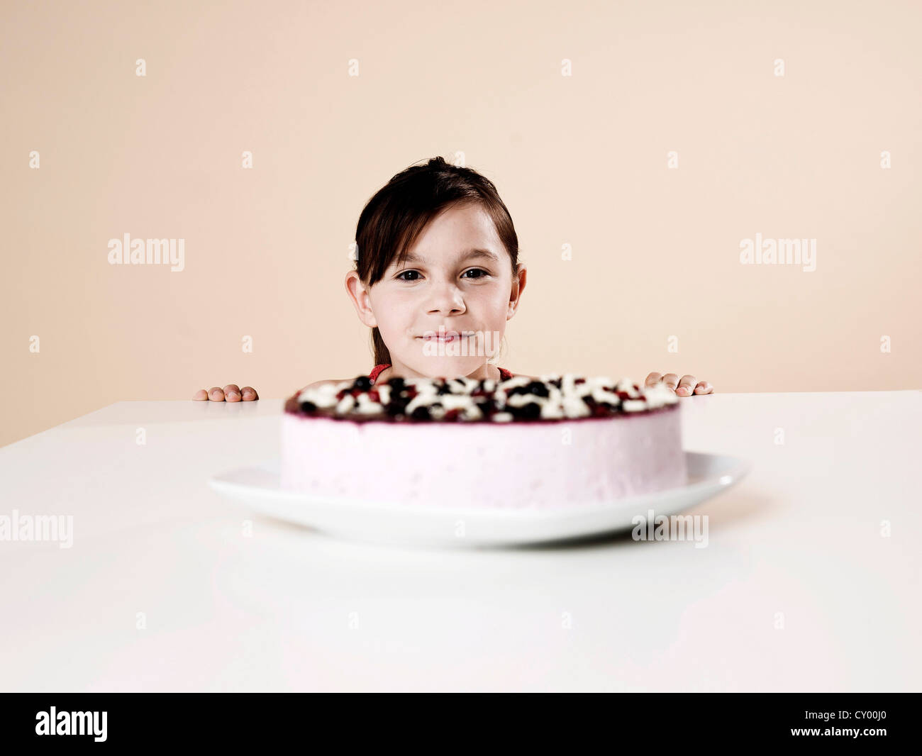 Girl looking hungrily towards a cake Stock Photo - Alamy