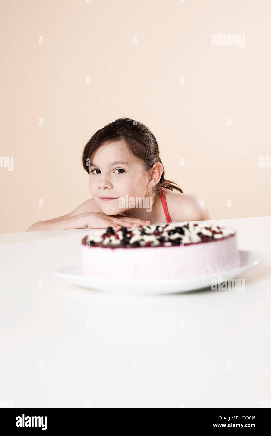 Girl looking hungrily towards a cake Stock Photo - Alamy