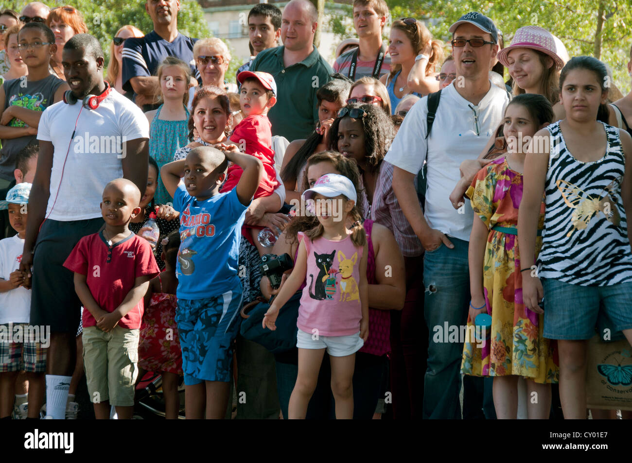 Mixed race group of people of mixed generations watching street ...