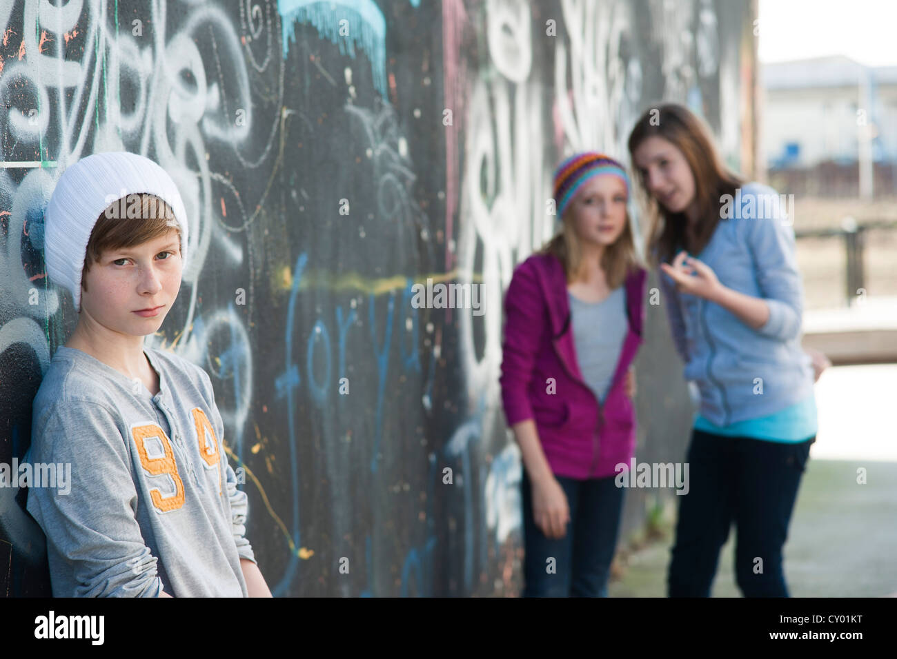 Two girls making fun of a boy Stock Photo - Alamy