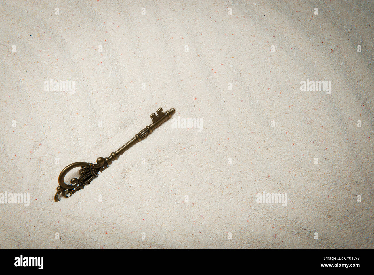 An old style key buried in the sand Stock Photo - Alamy