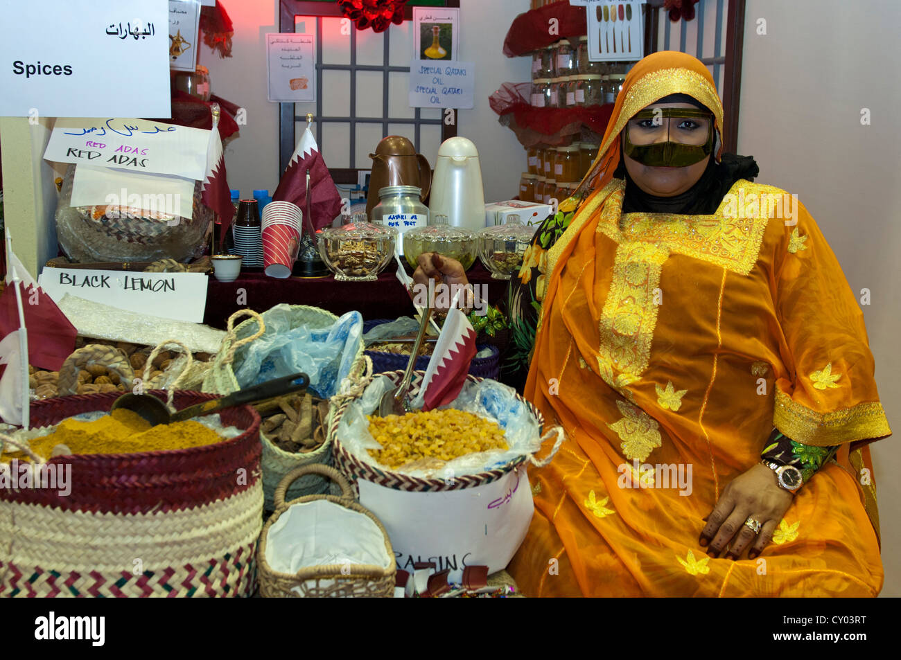 Spice merchant in traditional costume at her market stall, Doha, Qatar ...
