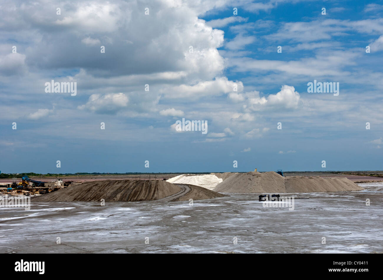 Cloudy sky above salt mounts at the seawater salt works Salins du Midi ...
