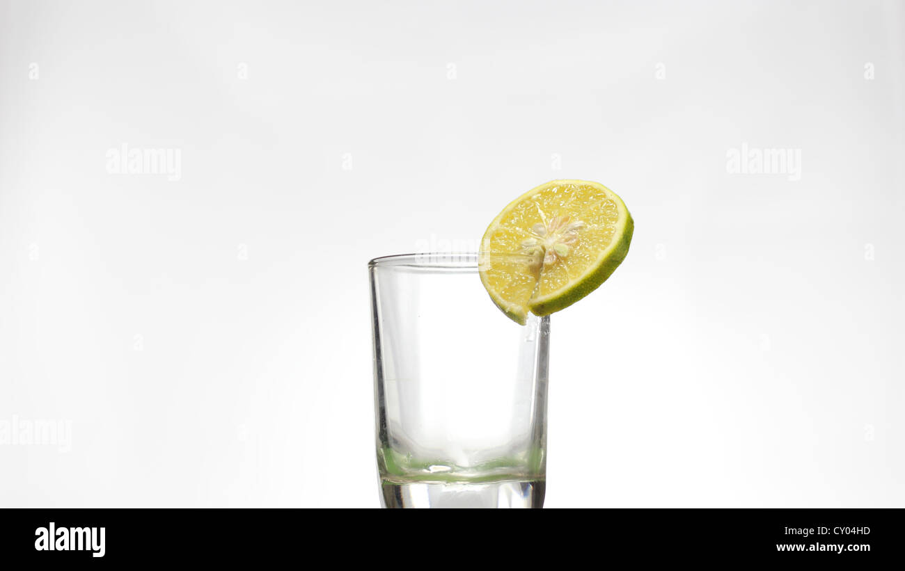 empty glass with lemon over white background Stock Photo - Alamy