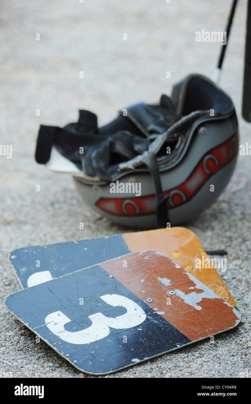 Helmet and two starting numbers lying on the ground, harness racing ...