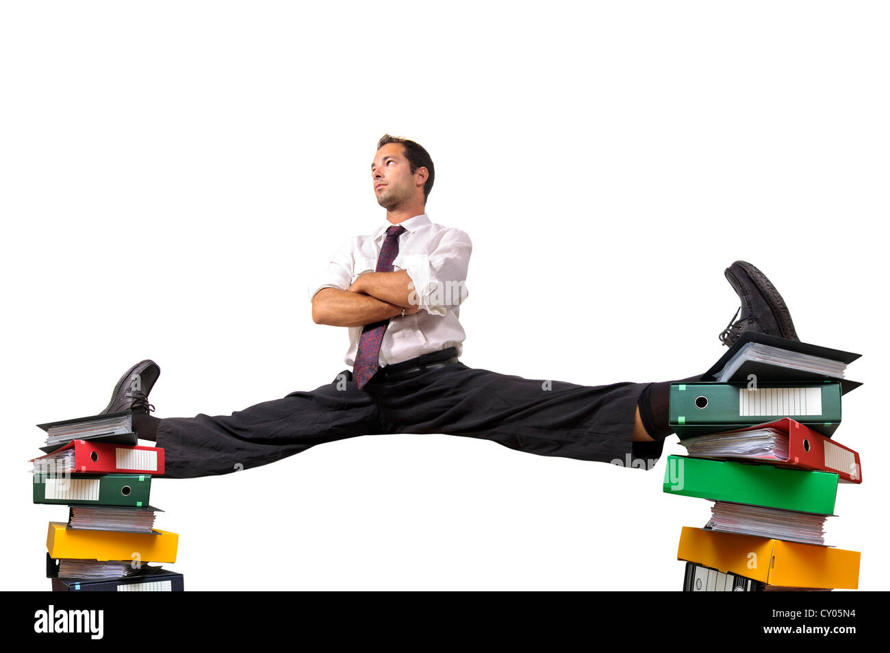 Businessman doing splits over stack of files Stock Photo - Alamy