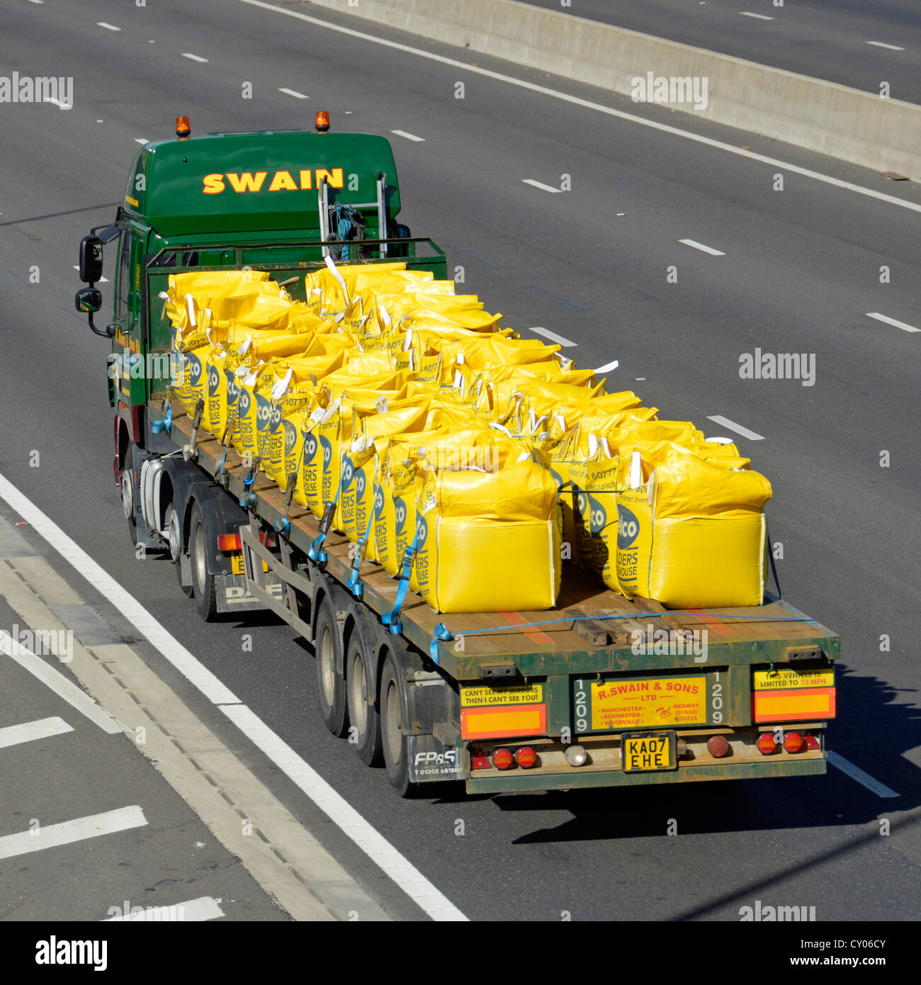 Articulated lorry on motorway loaded with large bags of loose bulk ...